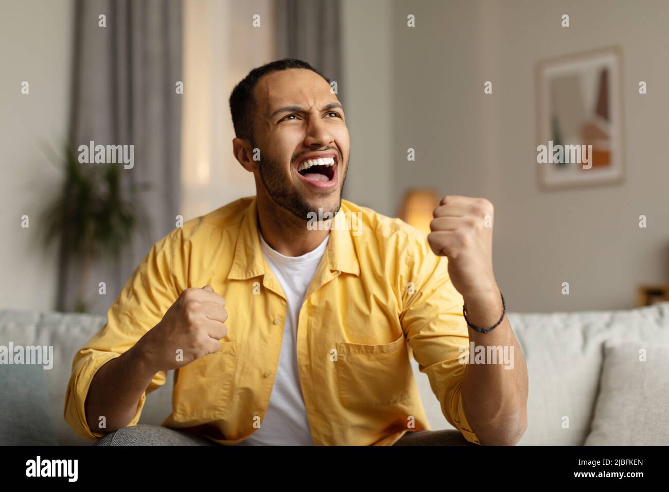 Emotional young black man shouting, gesturing YES in joy, celebrating ...