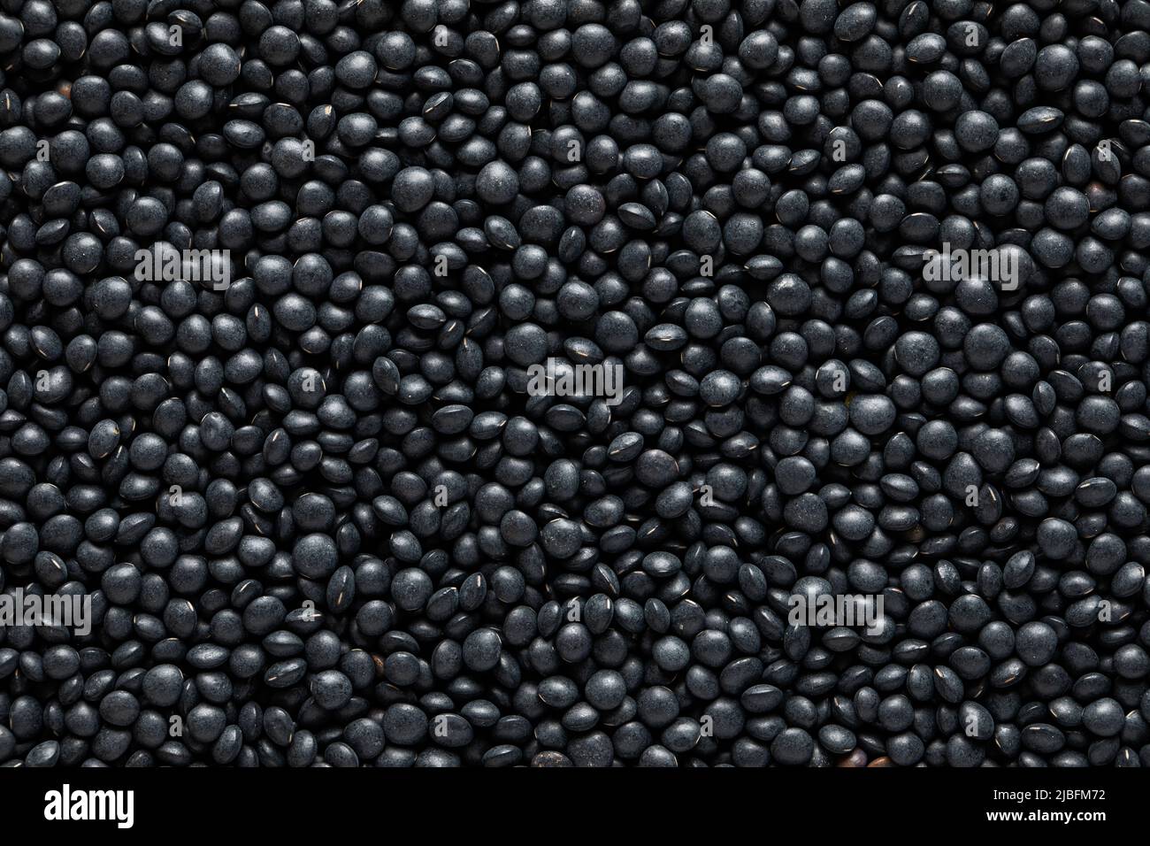 Background pile of healthy dried small round black lentils seeds ...