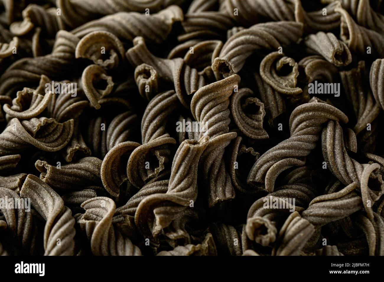 Close-up view of raw basil flavored sedanini pasta Stock Photo - Alamy
