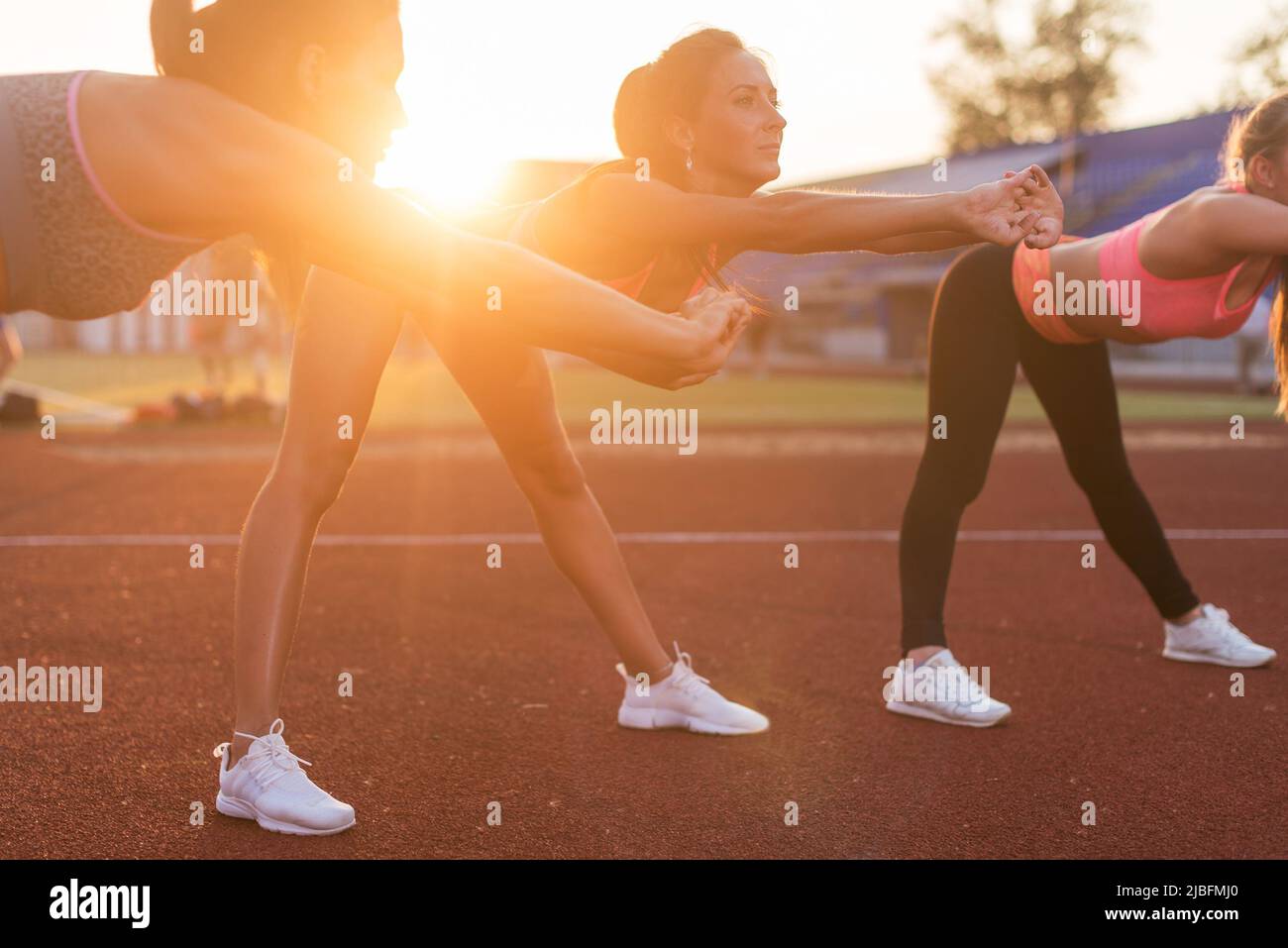 Young women performing warming up, stretching together Stock Photo - Alamy