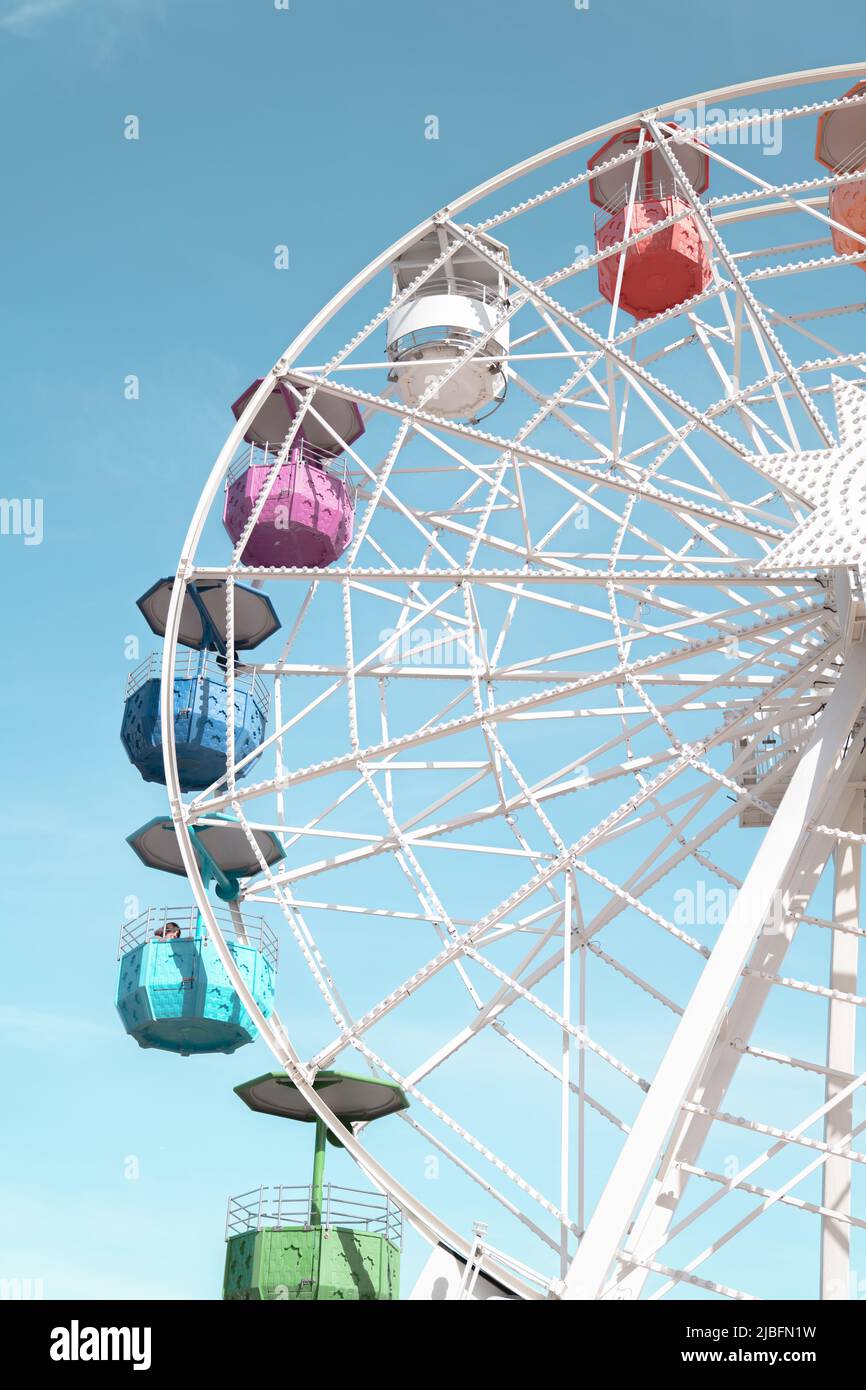 From below white Ferris wheel with colorful carts located against ...