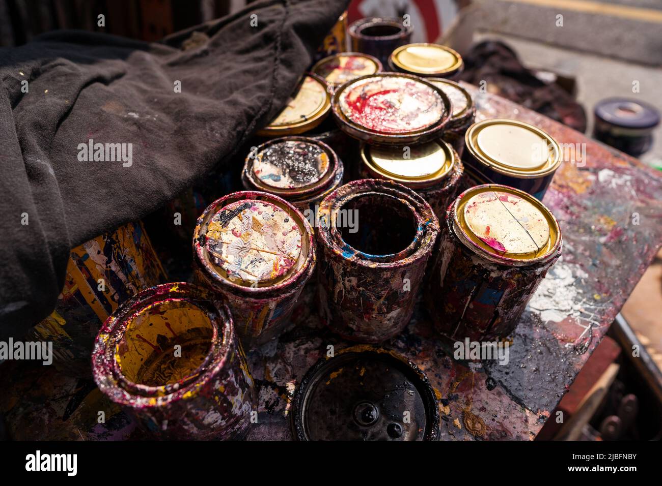 From above of messy metal cans with colorful paints placed on wooden ...