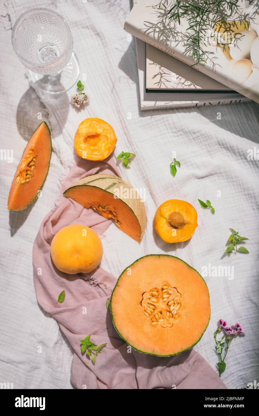 From above rockmelon sweet melon and peach slice near glass placed on ...