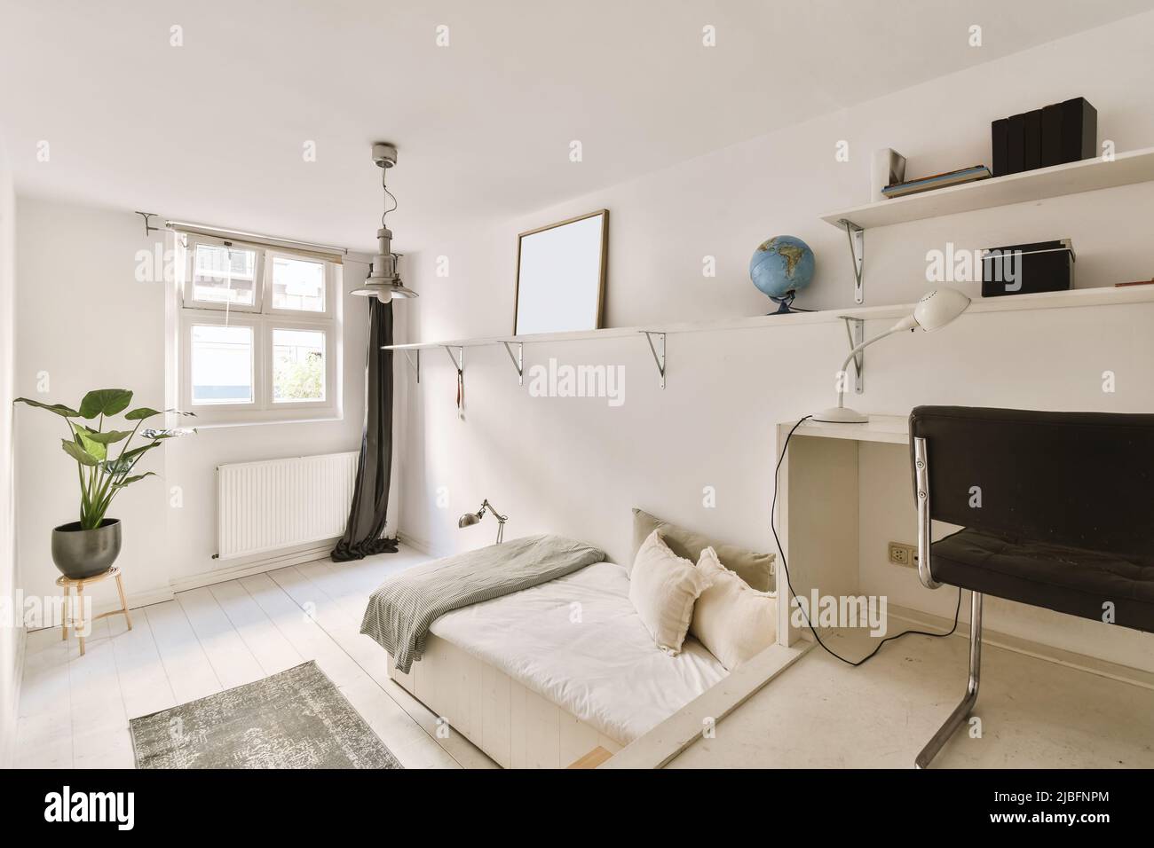 Comfortable soft bed with cushions and workspace with table and chair ...