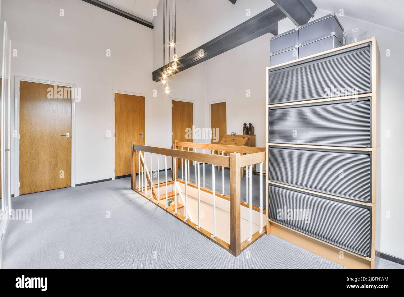 Interior in spacious mansard room with wooden wardrobes and staircase ...