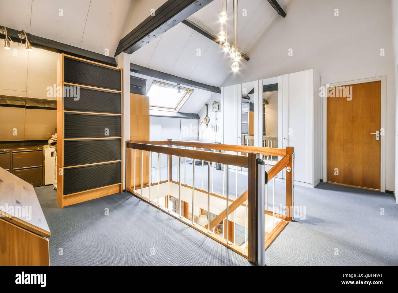 Interior in spacious mansard room with wooden wardrobes and staircase ...
