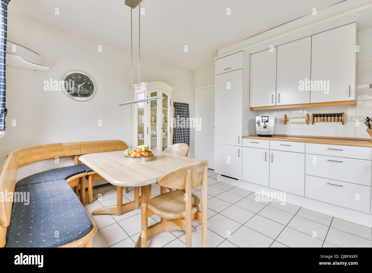 Wooden dining table with chairs and settee bench placed in modern ...
