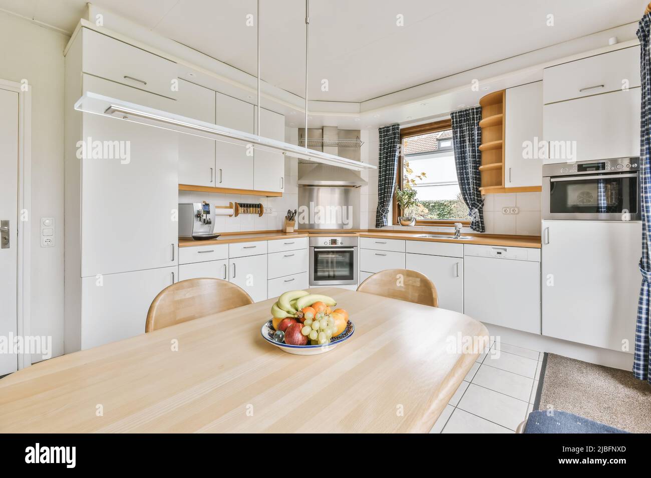 Wooden dining table with chairs and settee bench placed in modern ...