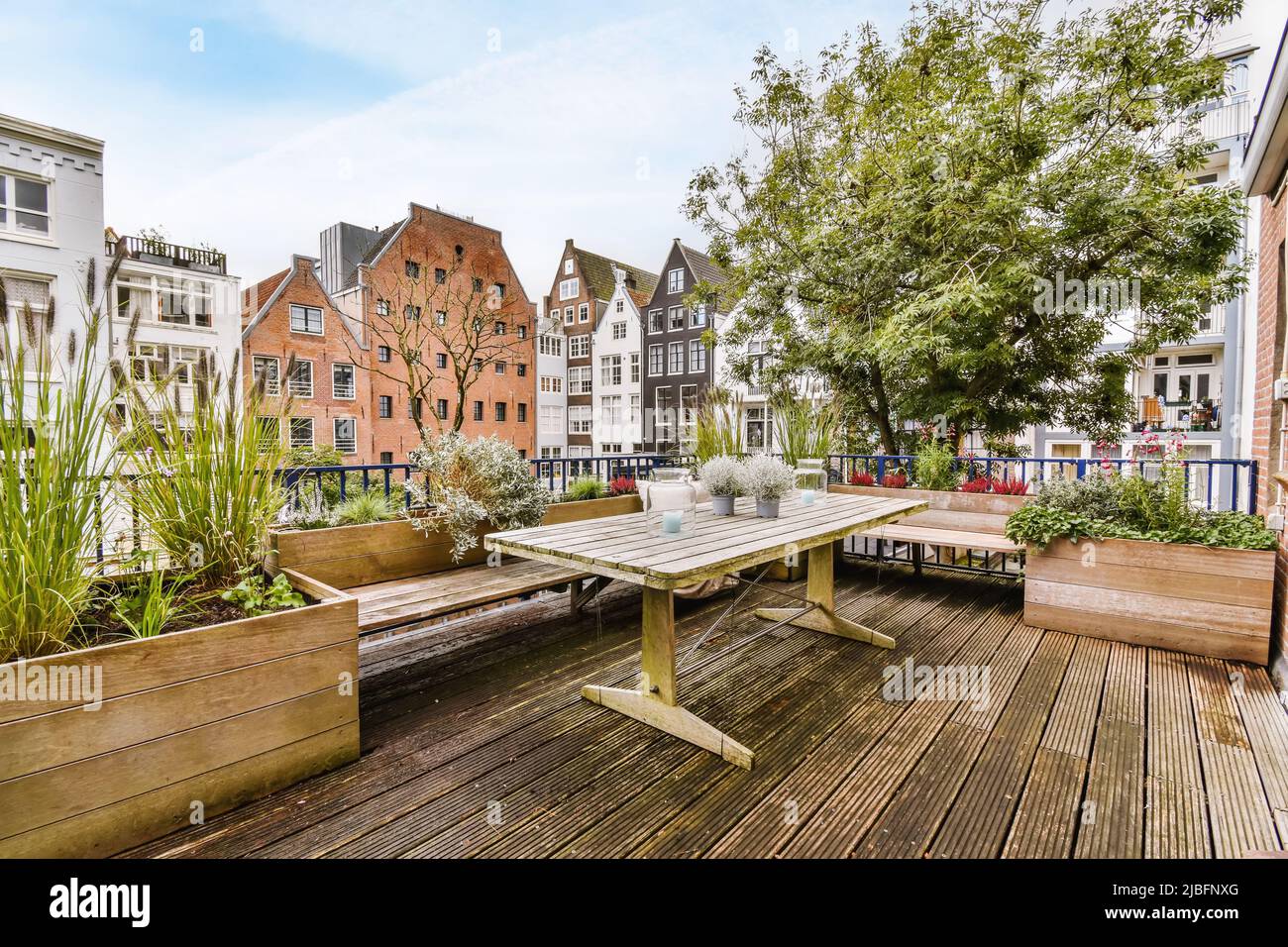 Spacious veranda with wooden table and various plants in multistory ...