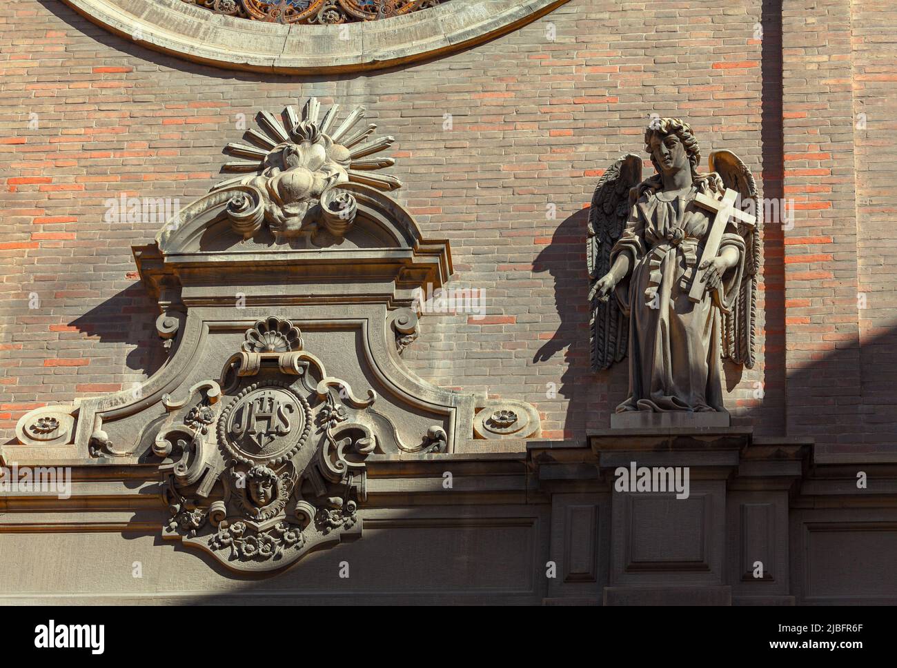 Sculptures at church wall . Carved angel with cross Stock Photo - Alamy