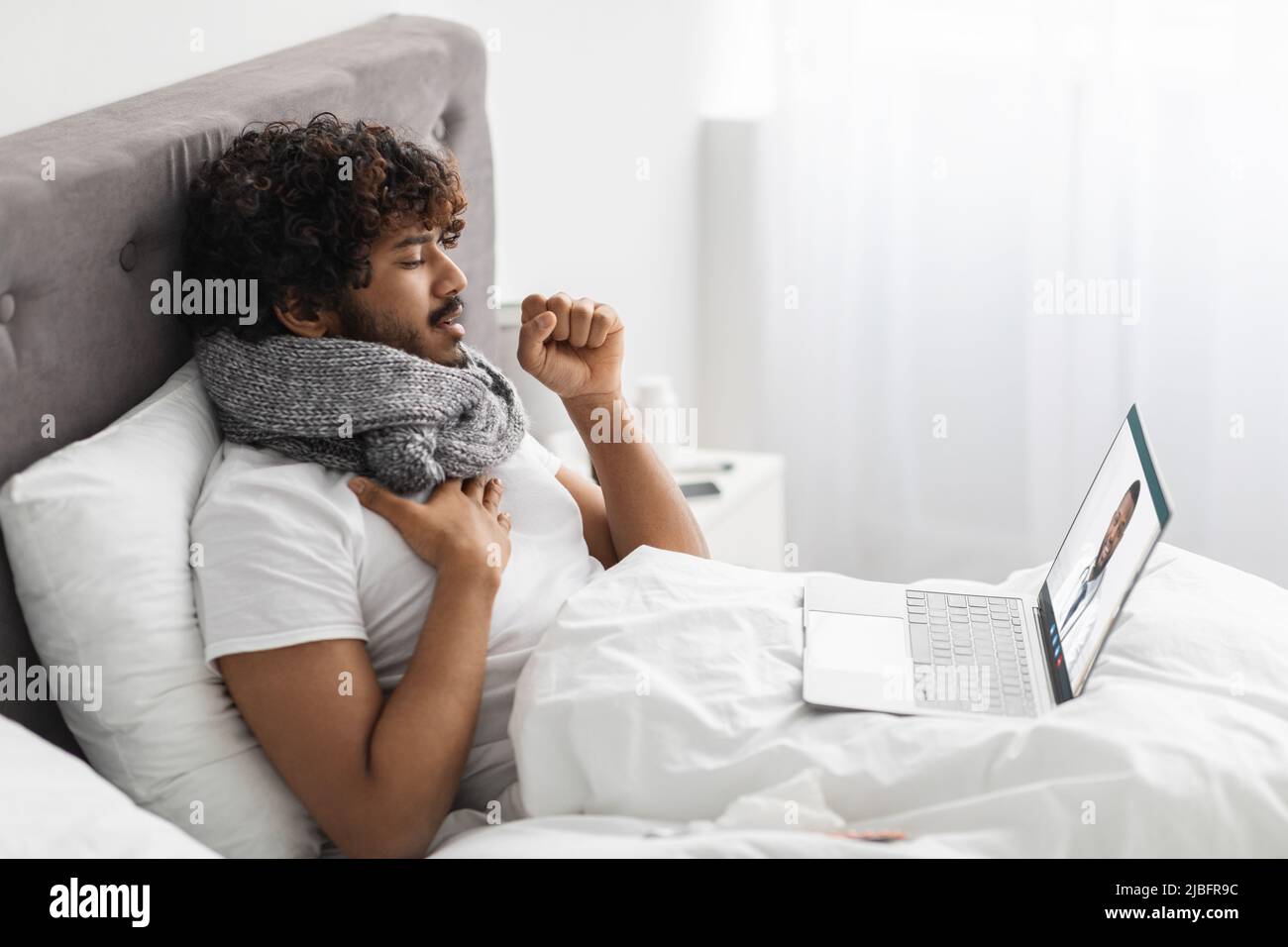 Sick indian man talking to doctor, using laptop Stock Photo - Alamy