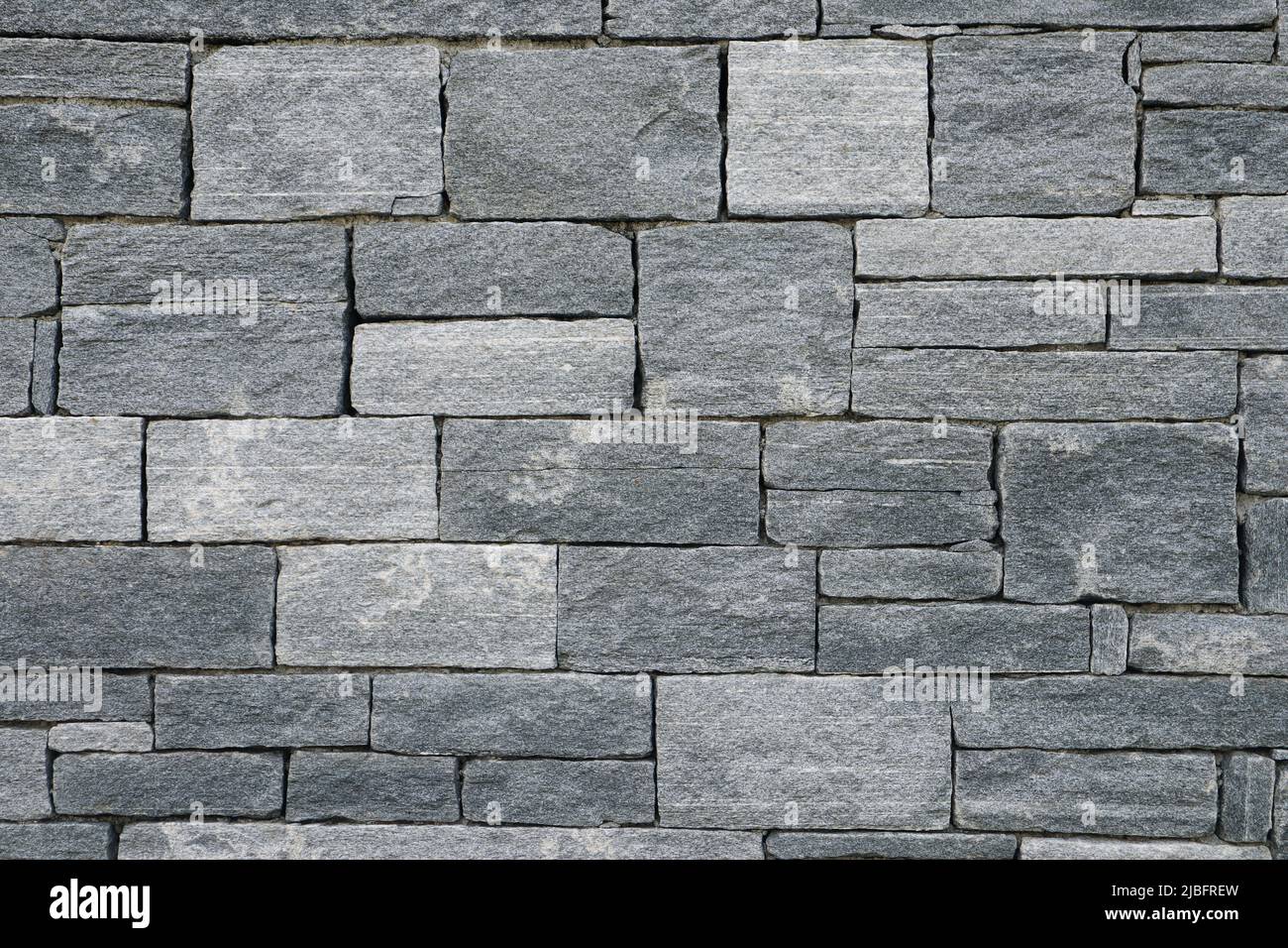Big and small Bricks in a grey Stone Wall Stock Photo - Alamy
