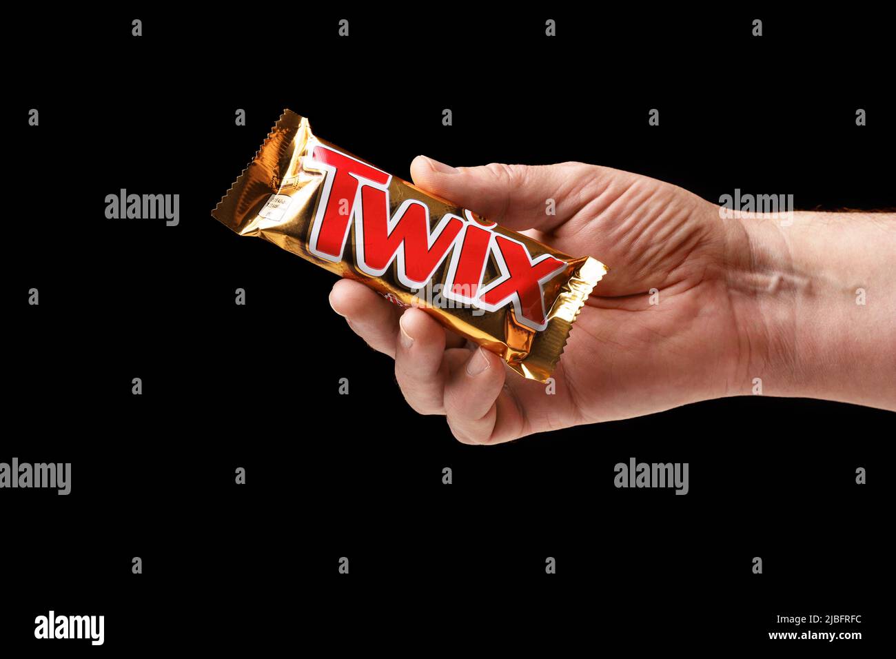Chocolate bar Twix in a man's hand close-up, black background Stock ...