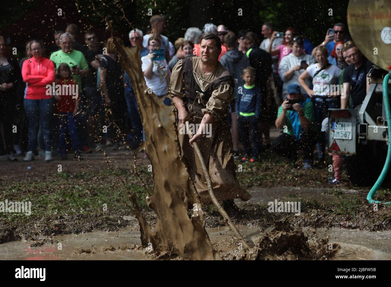Hergisdorf, Germany. 06th June, 2022. Men sit in a mud hole at the 2022 ...