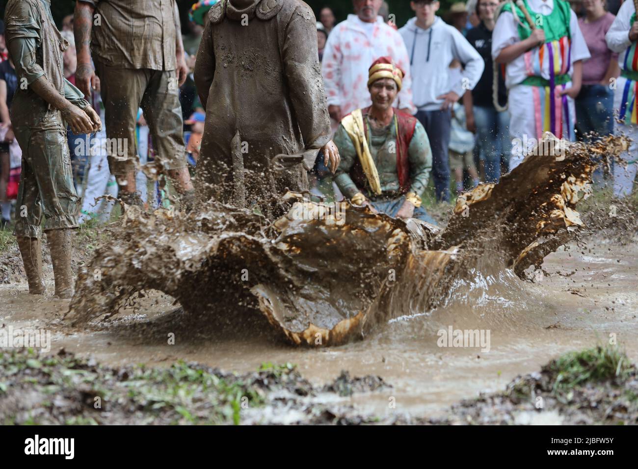 Hergisdorf, Germany. 06th June, 2022. Men sit in a mud hole at the 2022 ...