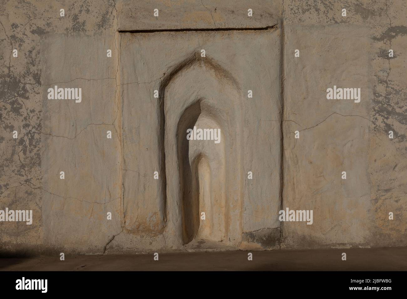 An old traditional mihrab carved into a plastered wall, showcasing ...