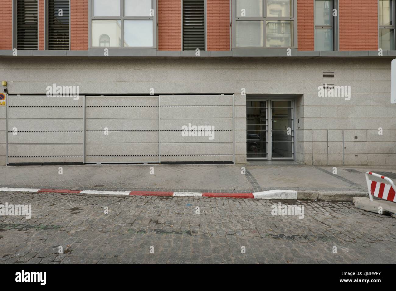 Facade of urban residential buildings with access to a garage next to ...