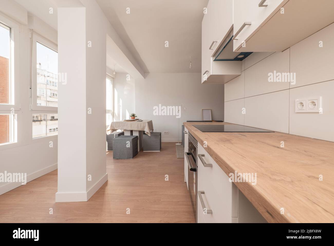 new open plan kitchen with wood counters, white cabinets and stainless ...