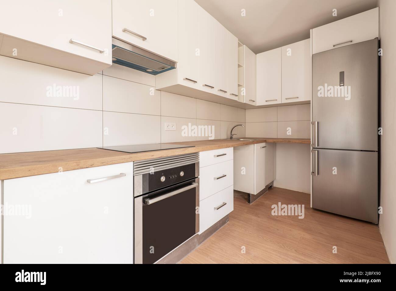 new open kitchen with wood counters, white cabinets and stainless steel ...