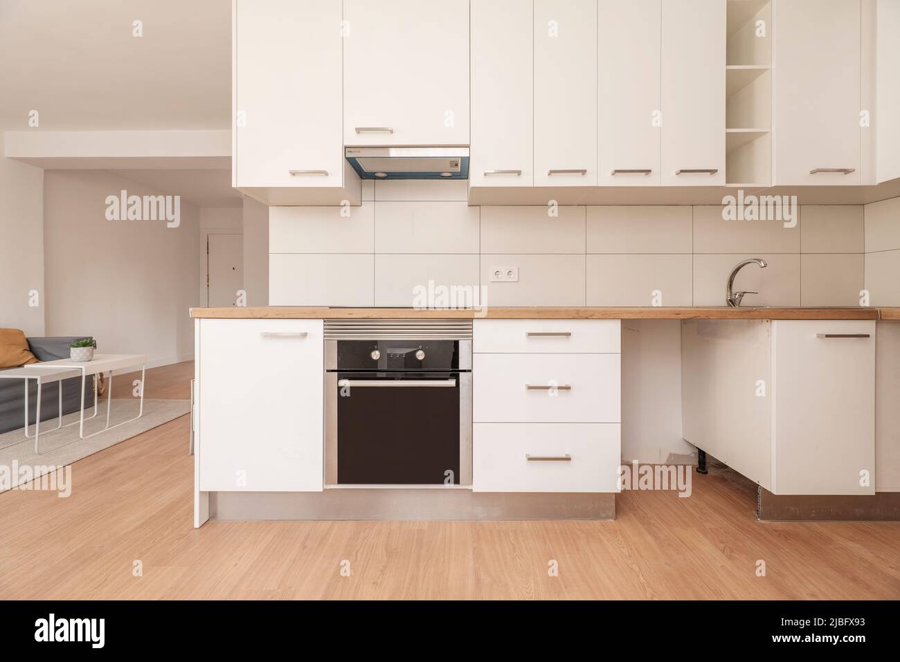 Front view of a new open plan kitchen with wood counters, white ...
