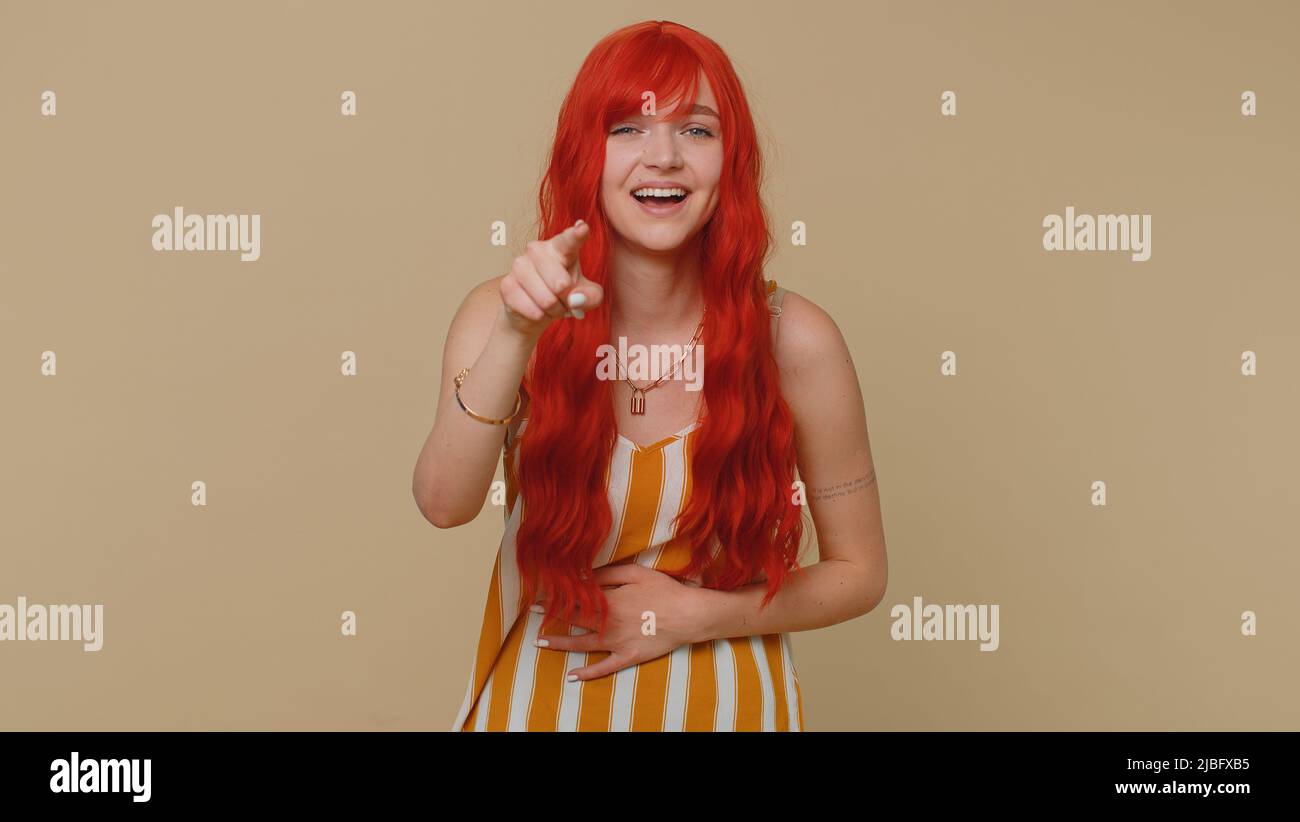 Amused ginger woman in tank top pointing finger to camera, laughing out ...