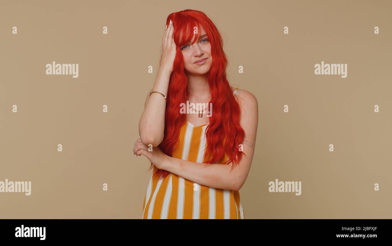 Red hair young woman in tank top rubbing temples to cure headache ...