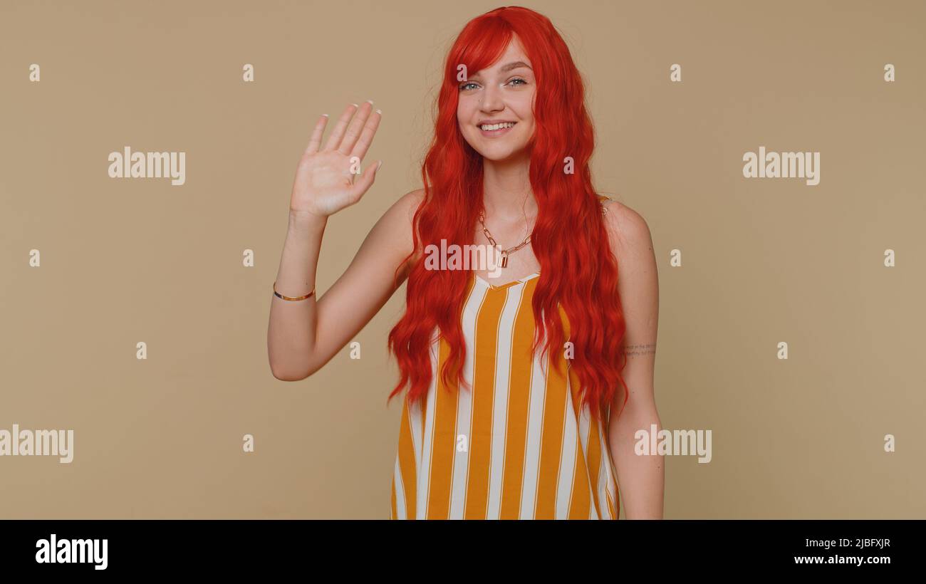 Beautiful redhead woman smiling friendly at camera and waving hands ...