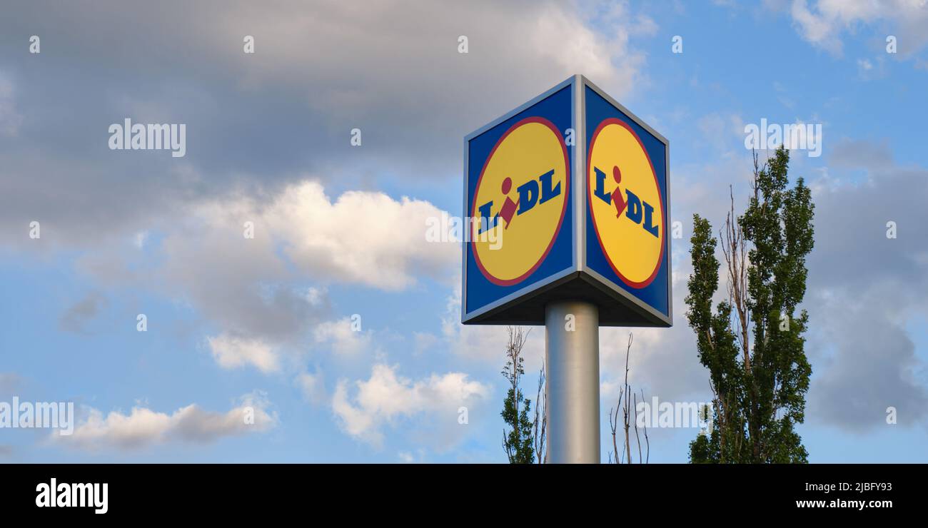 Lidl logo sign on tall pole and clouds, with copy space. Lidl is a ...