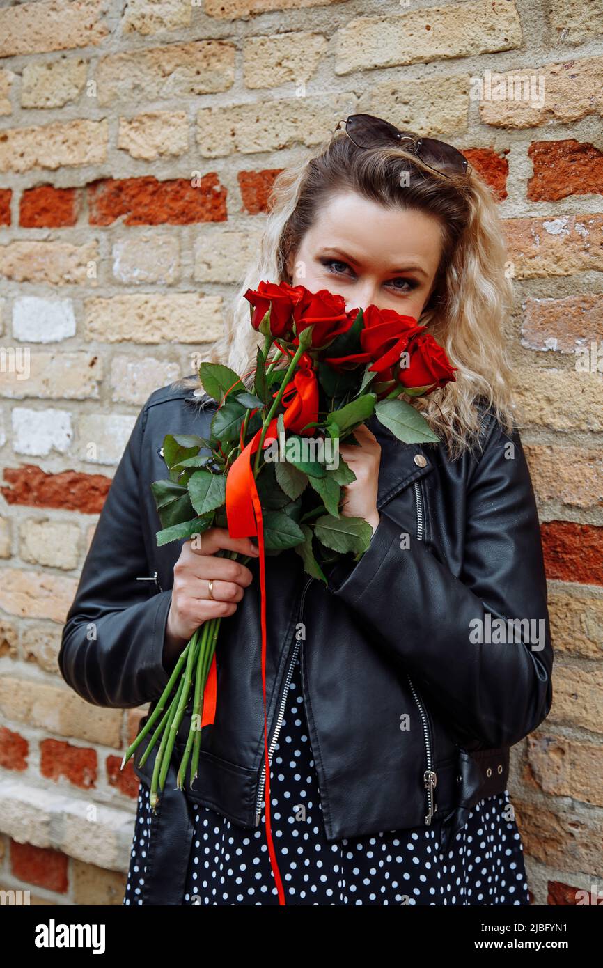 Vertical portrait of glad blond woman on first date anniversary with ...