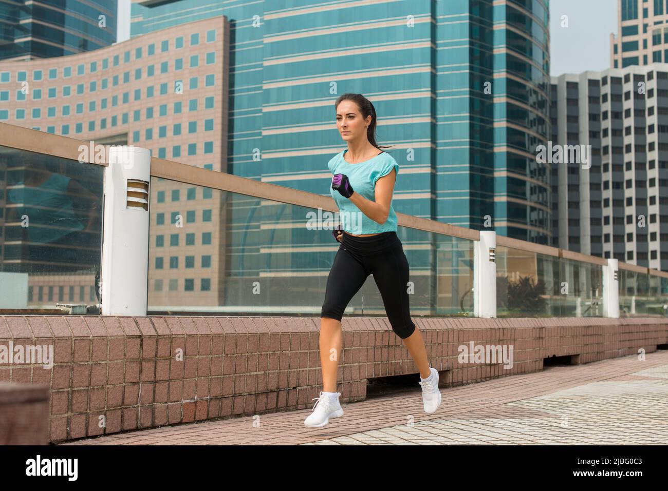 Attractive sporty young woman running on pavement Stock Photo - Alamy