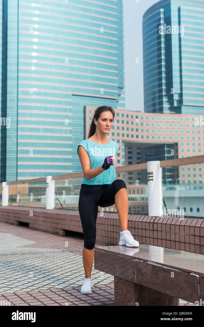 Concentrated young female athlete doing jump step ups exercise on bench ...