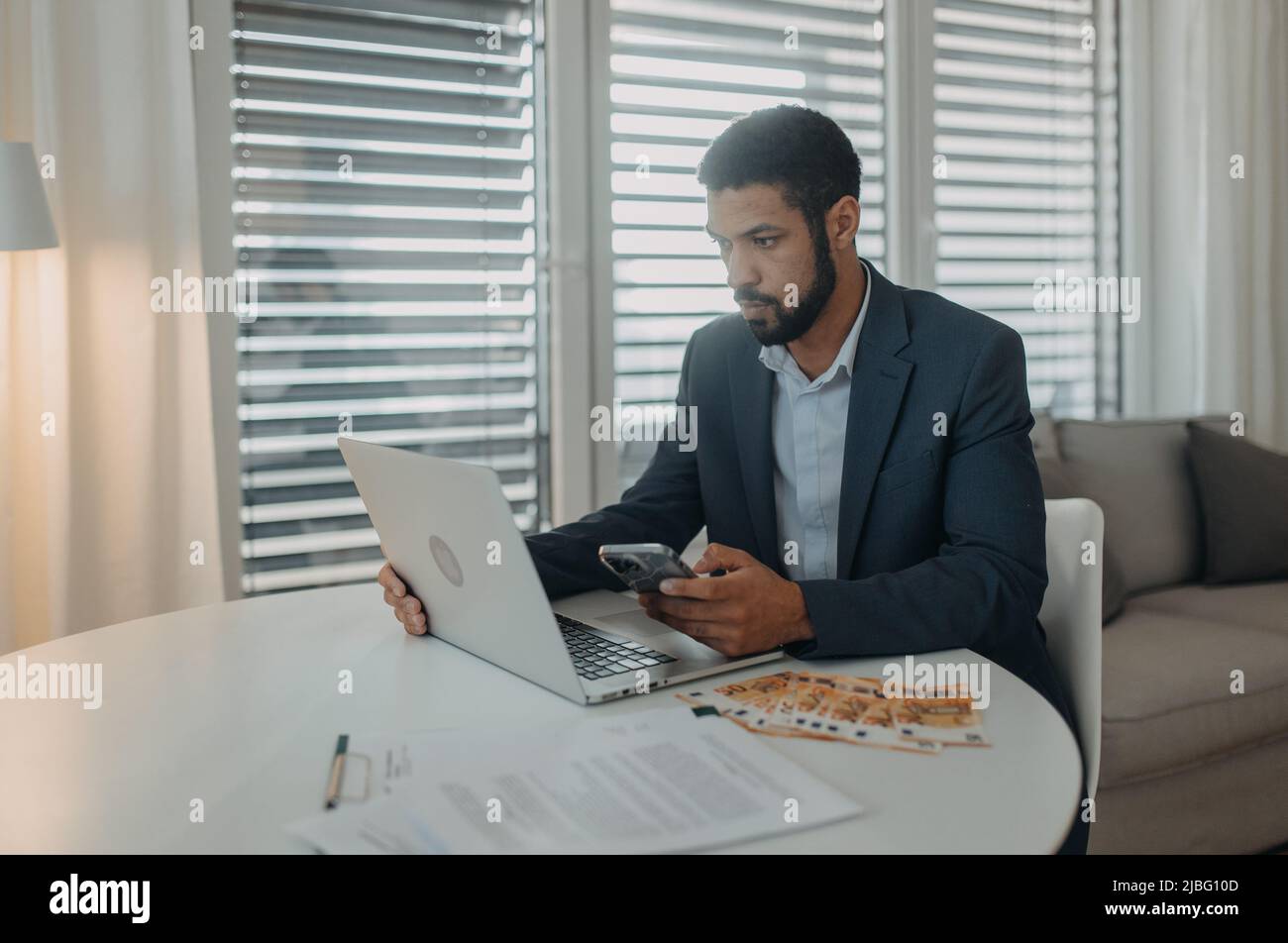 Depressed businessman man counting euro money working on computer at ...
