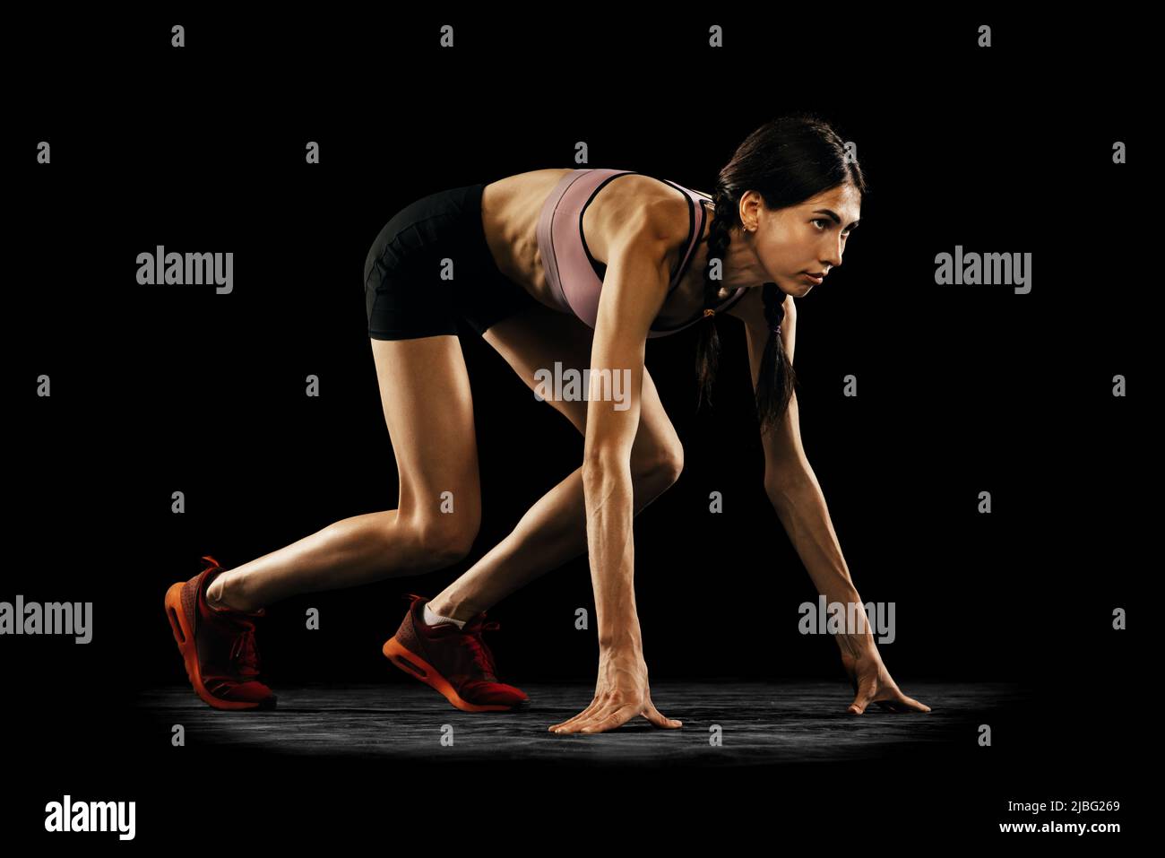 Ready to start. Studio shot of young muscular woman running isolated on ...