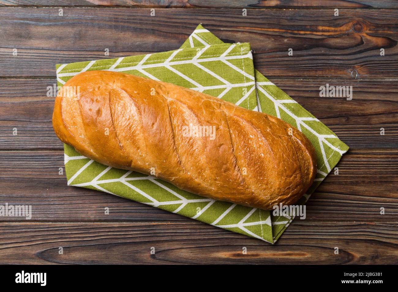 freshly baked bread with napkin on rustic table top view. Healthy white ...