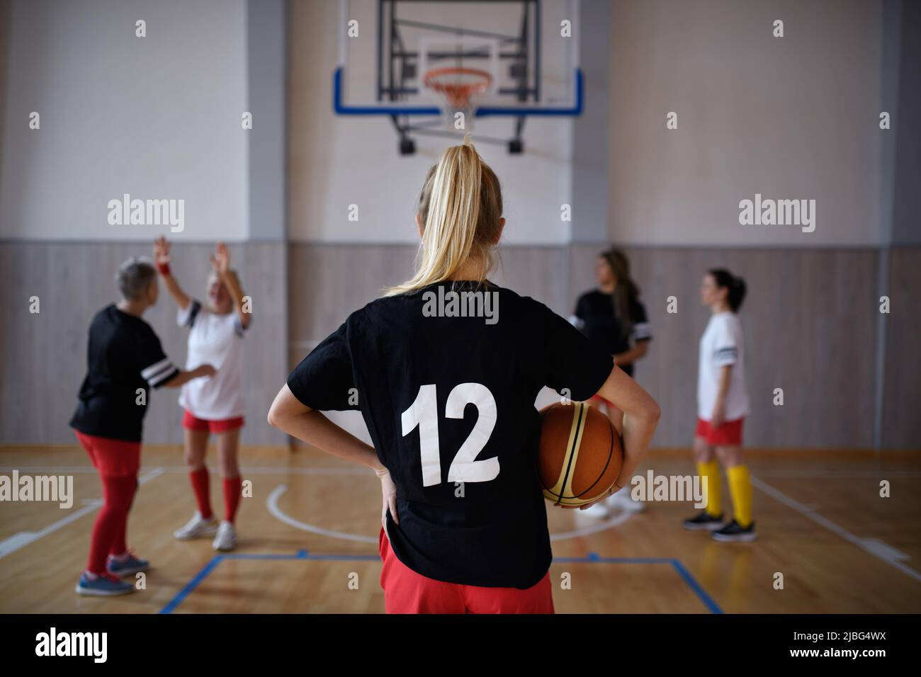 A rear view of young woman basketball player in gym during match Stock ...