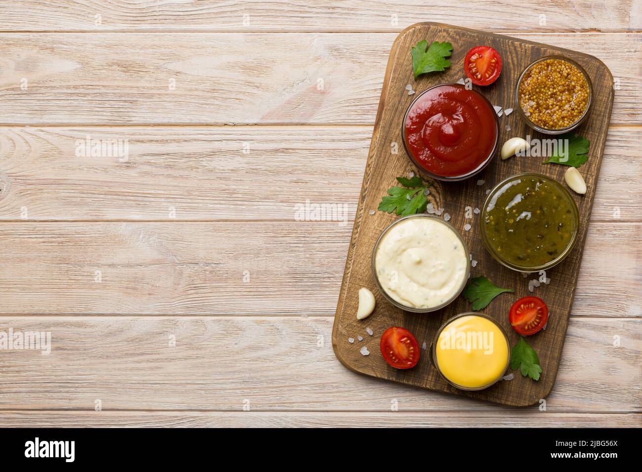 Many different sauces and herbs on table, flat lay top view. sauces on ...