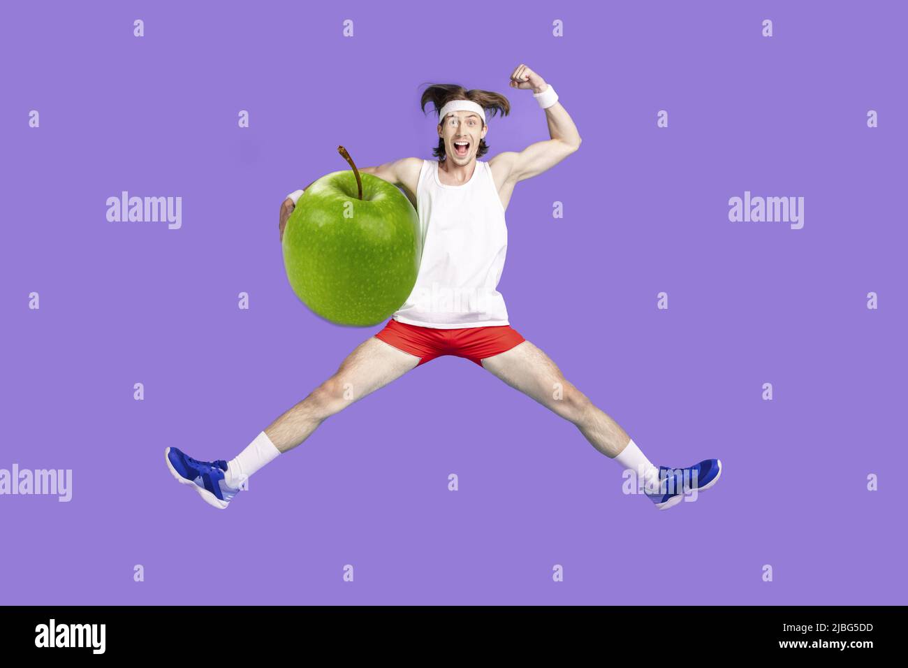 Overjoyed crazy guy jumping high hold giant apple have snack before ...