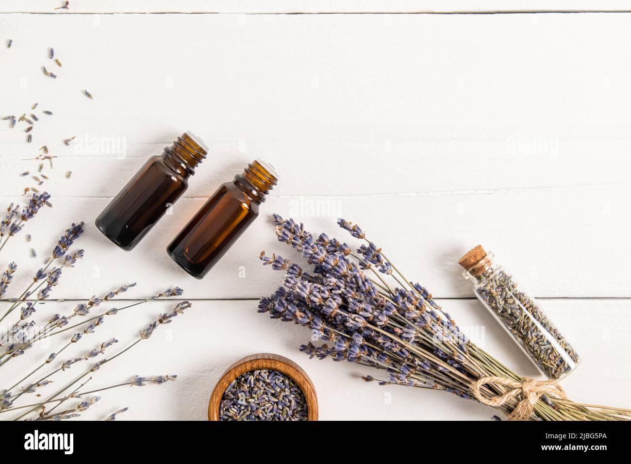 two bottles of dark glass with lavender essential oil, a bouquet of dry ...