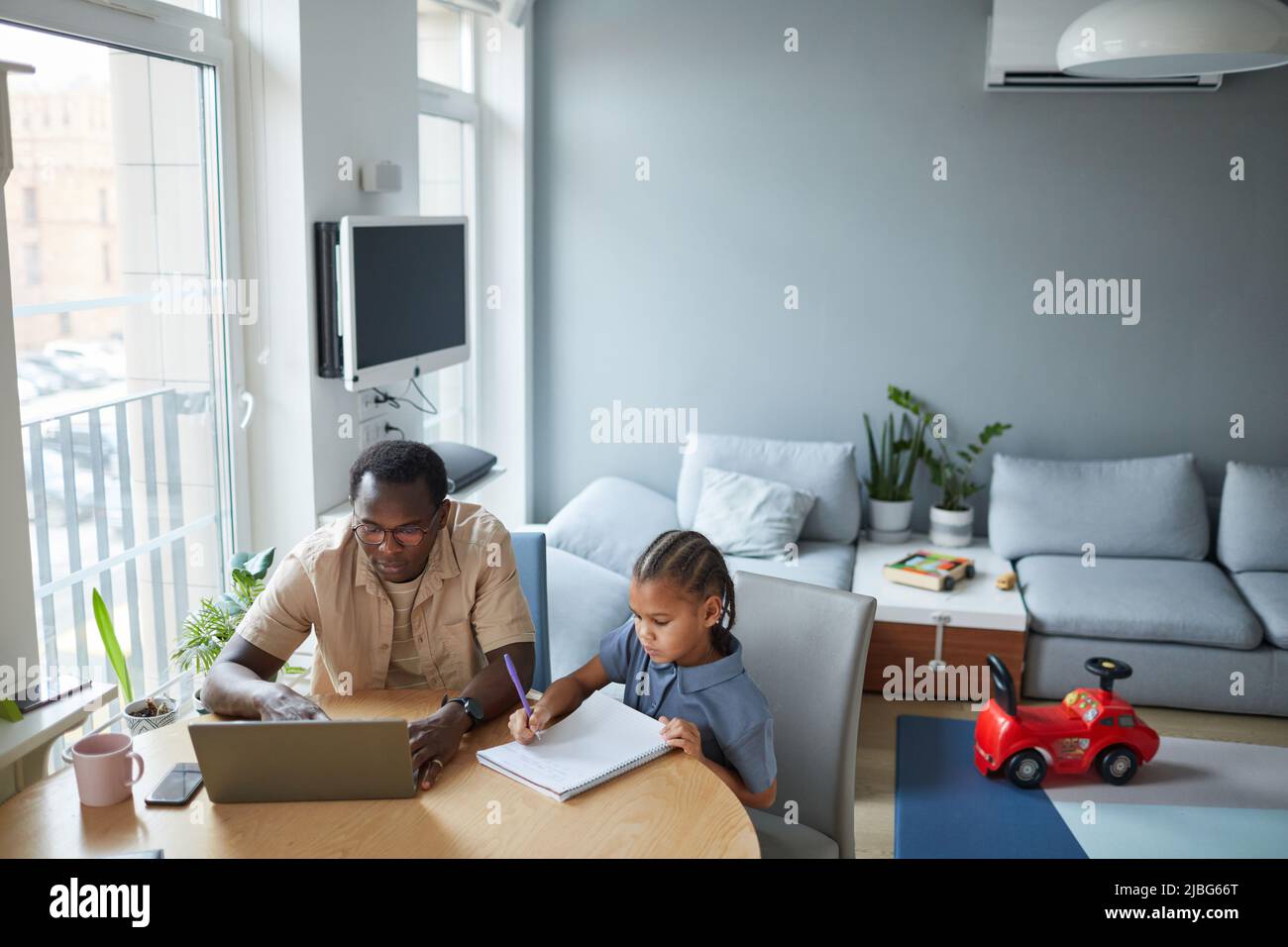 High angle portrait of African American man working from home and using ...