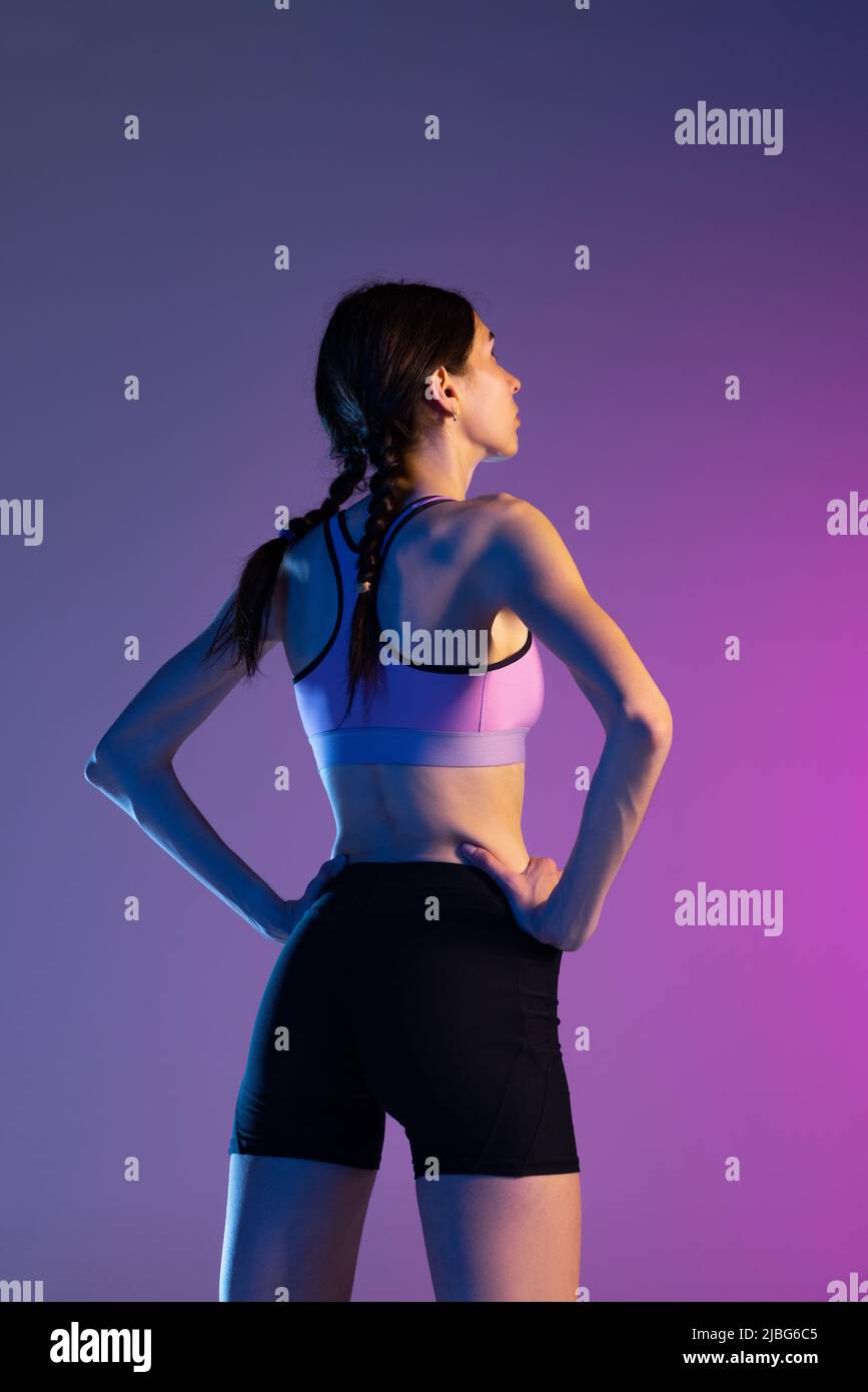 Back view. Young fitness girl, female athlete in sports uniform posing ...