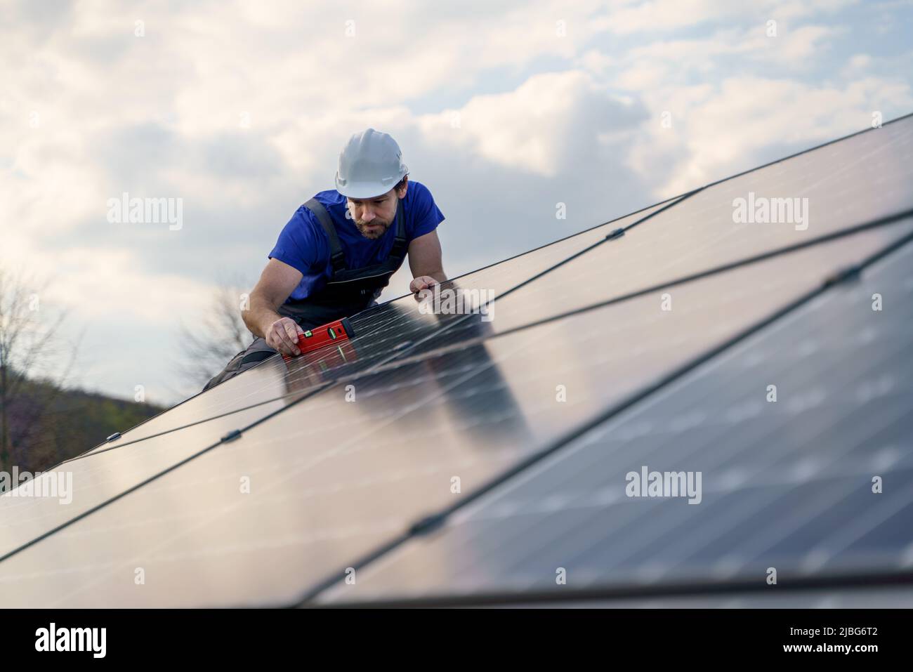 Man worker installing solar photovoltaic panels on roof, alternative ...