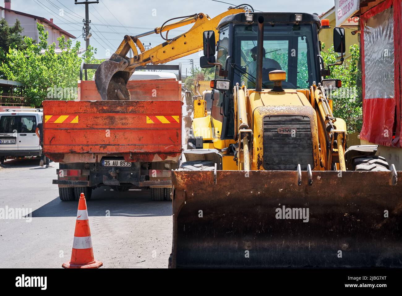 Urla, İzmir, Turkey - May 2022: Excavator dumping soil to a dump truck ...