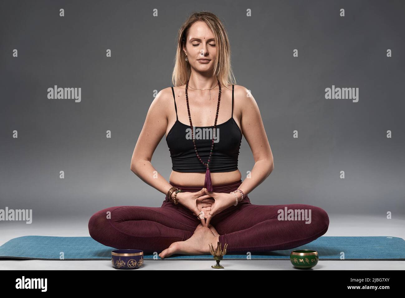 Young woman yoga trainer in various asana postures (poses) studio shot ...