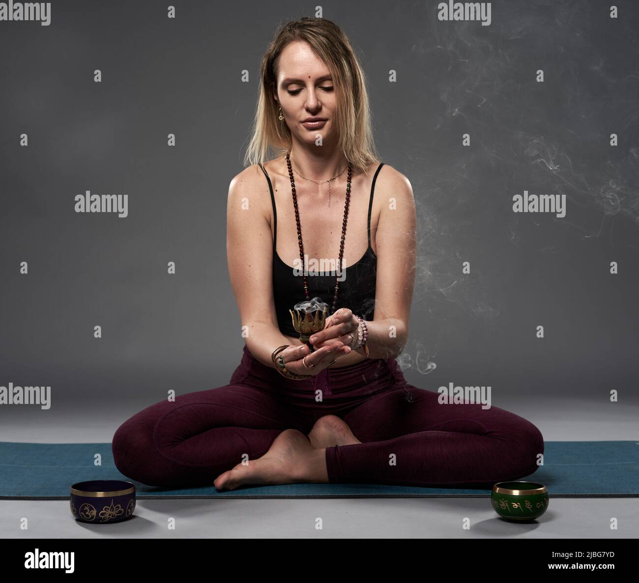 Young woman yoga trainer in various asana postures (poses) studio shot ...