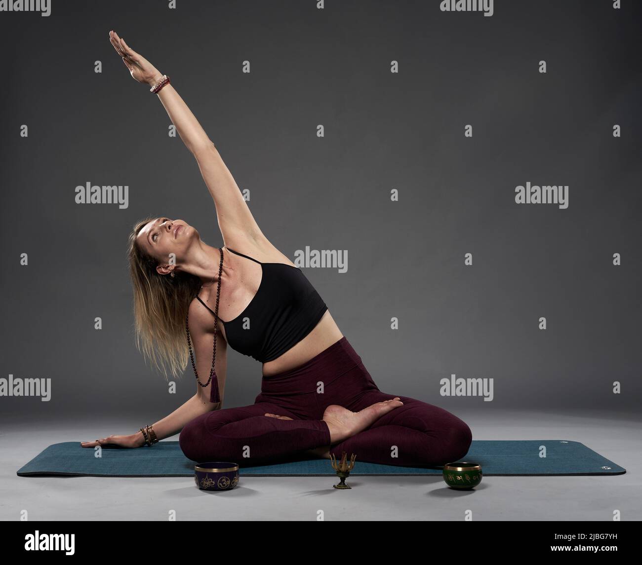 Young woman yoga trainer in various asana postures (poses) studio shot ...