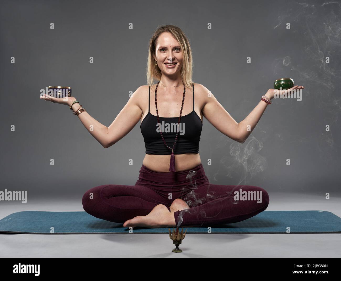 Young woman yoga trainer in various asana postures (poses) studio shot ...