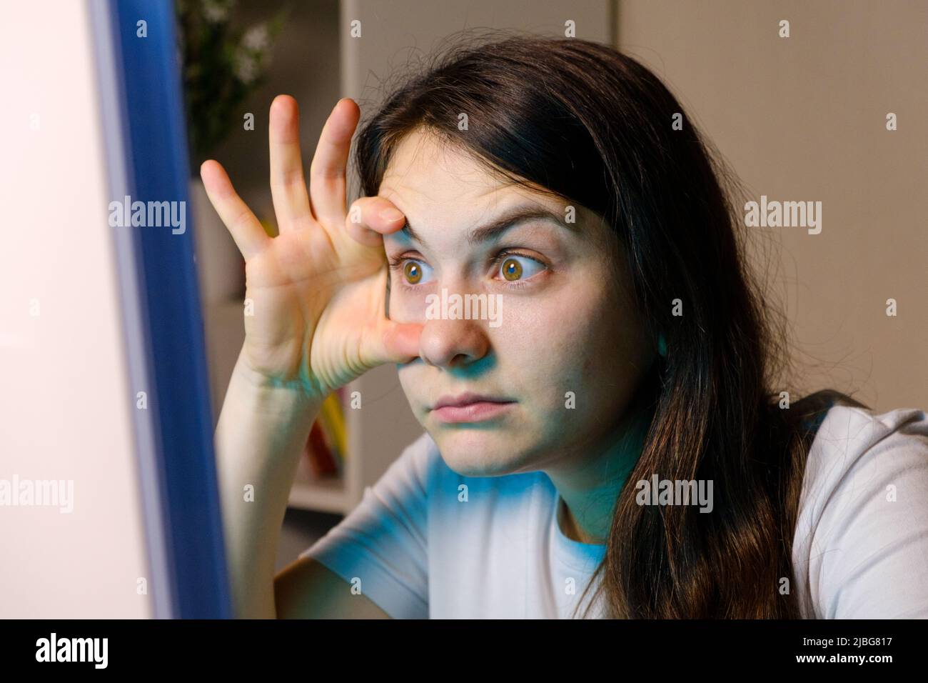 The woman forces herself to look into the computer screen, opening her ...