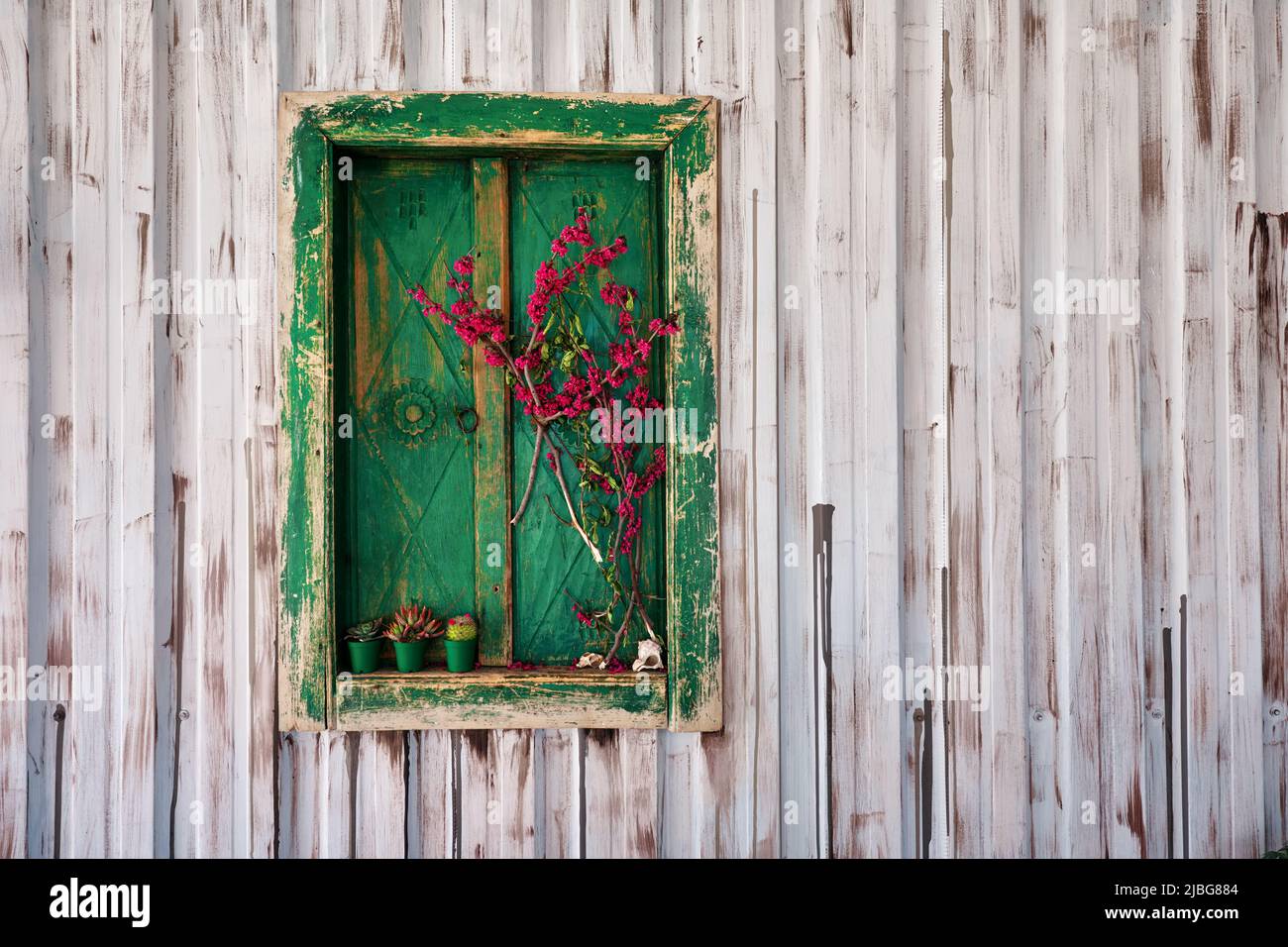 Green wooden antique window frame with shutters and decorated with ...