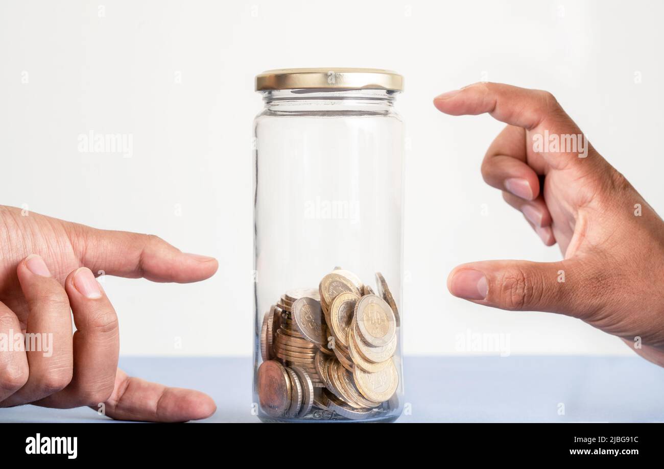 Close up photo hands pointing money collected and money missing as a ...