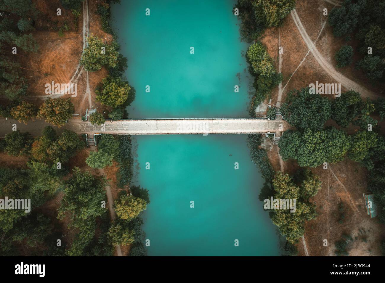 Beautiful bridge over the azure riverbed with clear water connects two ...